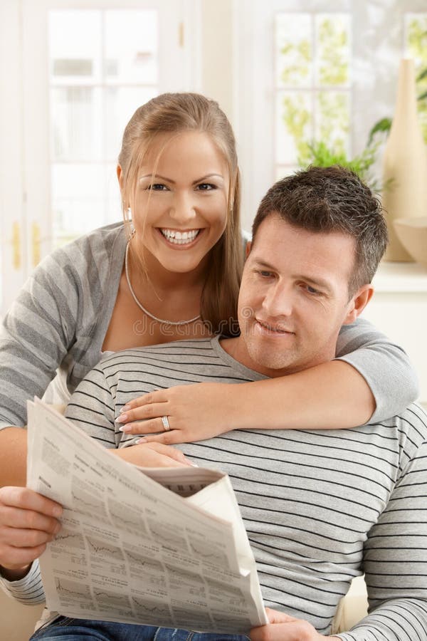 Couple reading newspaper stock photo. Image of color - 10612774