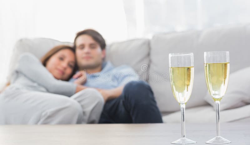 Couple Relaxing on a Couch with Flutes of Champagne Stock Photo - Image ...