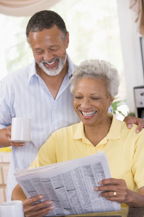 Couple Relaxing with a Newspaper Smiling Stock Photo - Image of camera ...
