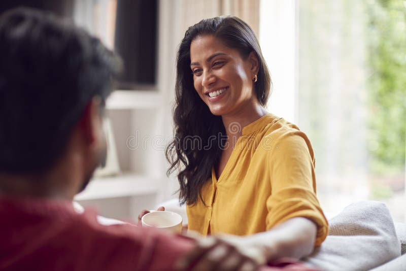 Couple Relaxing on Sofa at Home Together with Hot Drinks Stock Photo ...