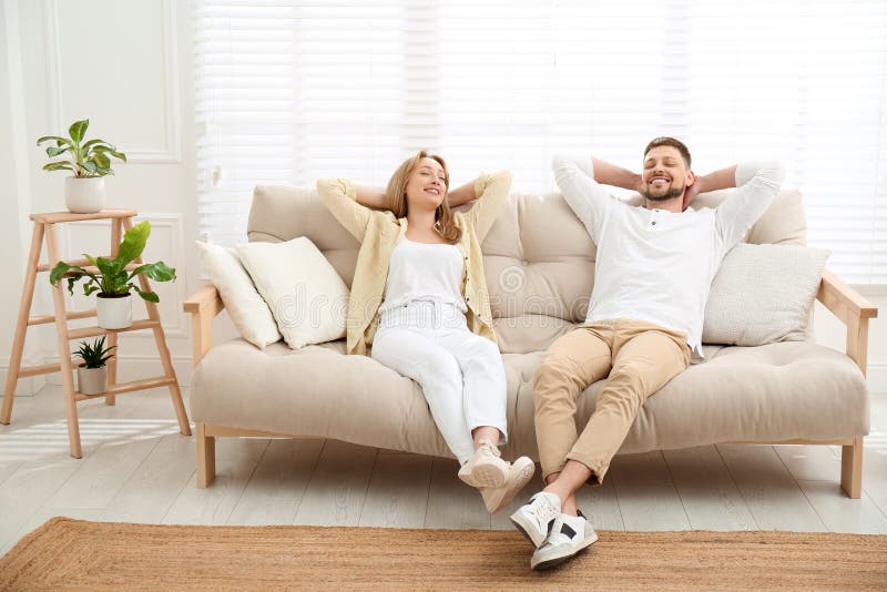 Couple Relaxing on Sofa in Living Room Stock Photo - Image of freedom ...