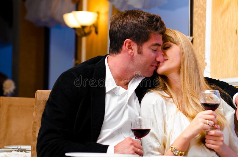 Young Couple Kissing In Restaurant Celebrating Or On Romantic D Stock