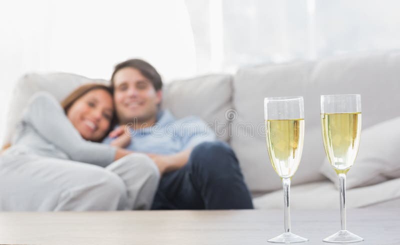 Couple Resting on a Couch with Flutes of Champagne Stock Photo - Image ...