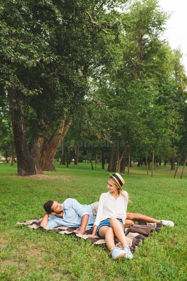 Young Couple Resting on Blanket on Ground Together Stock Image - Image ...