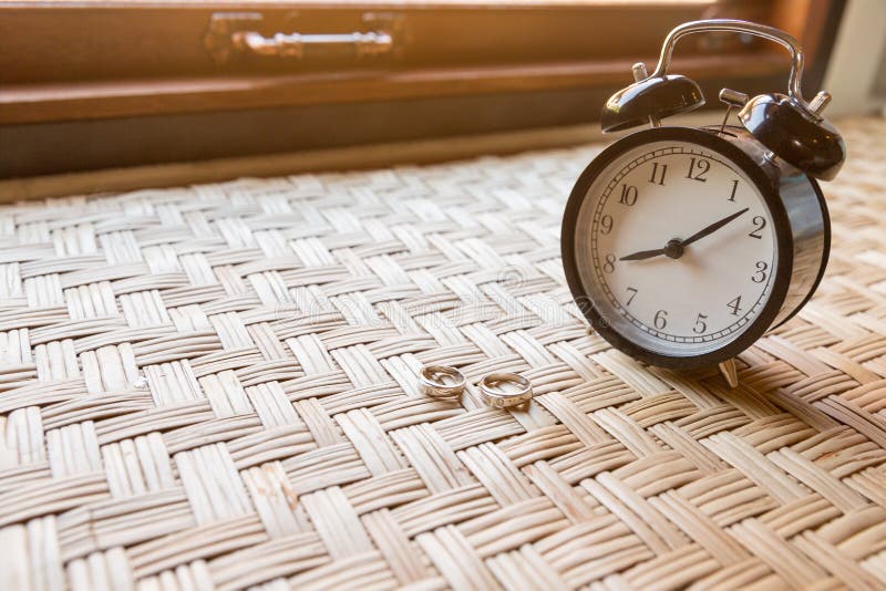 Couple Ring on Weave Table with Clock Stock Photo - Image of flower ...