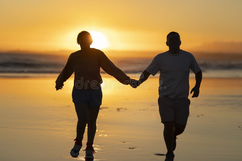 Couple Running on Beach at Sunset Holding Hands Stock Photo - Image of ...