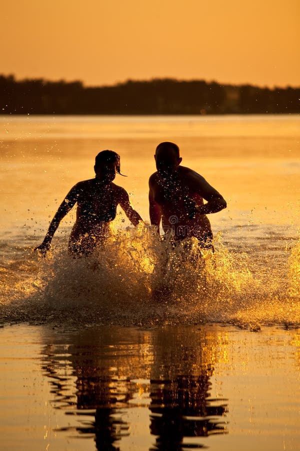 Couple running in lake stock image. Image of husband - 14533431