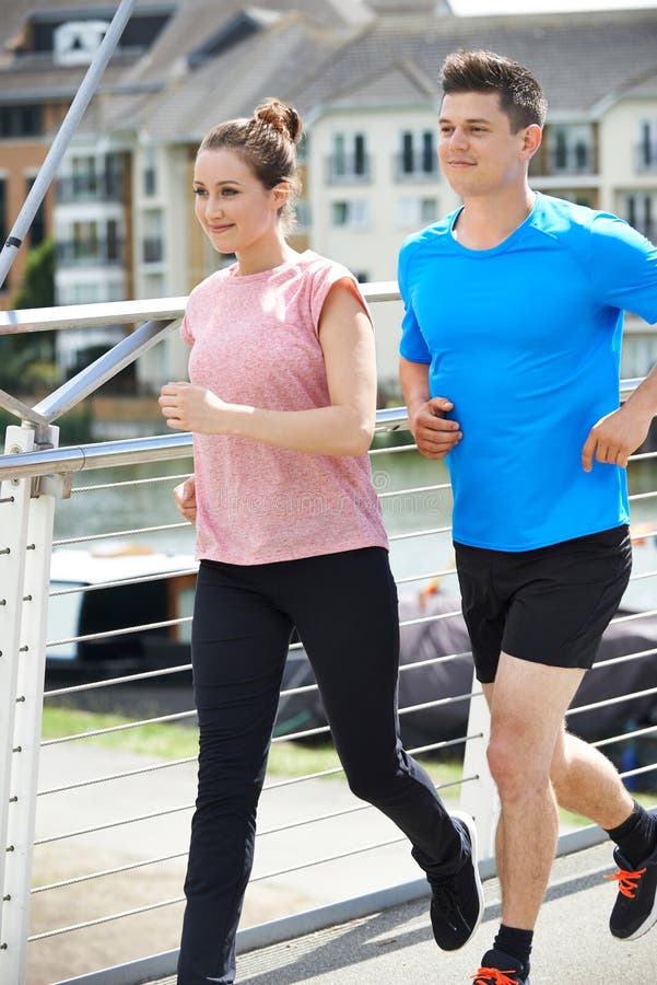 Young Couple Running in Urban Environment Stock Image - Image of ...