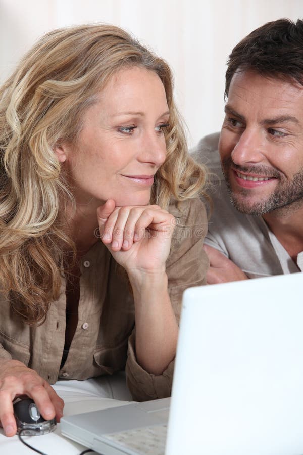 Couple sat by computer stock photo. Image of relaxation - 23350558