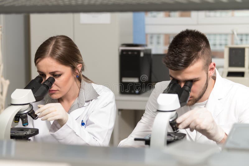 Couple of Scientists Looking into a Microscope Stock Photo - Image of ...