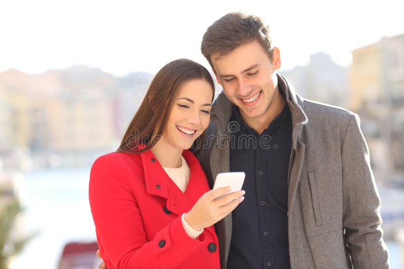 Couple Sharing Media in a Smart Phone in a Park Stock Photo - Image of ...
