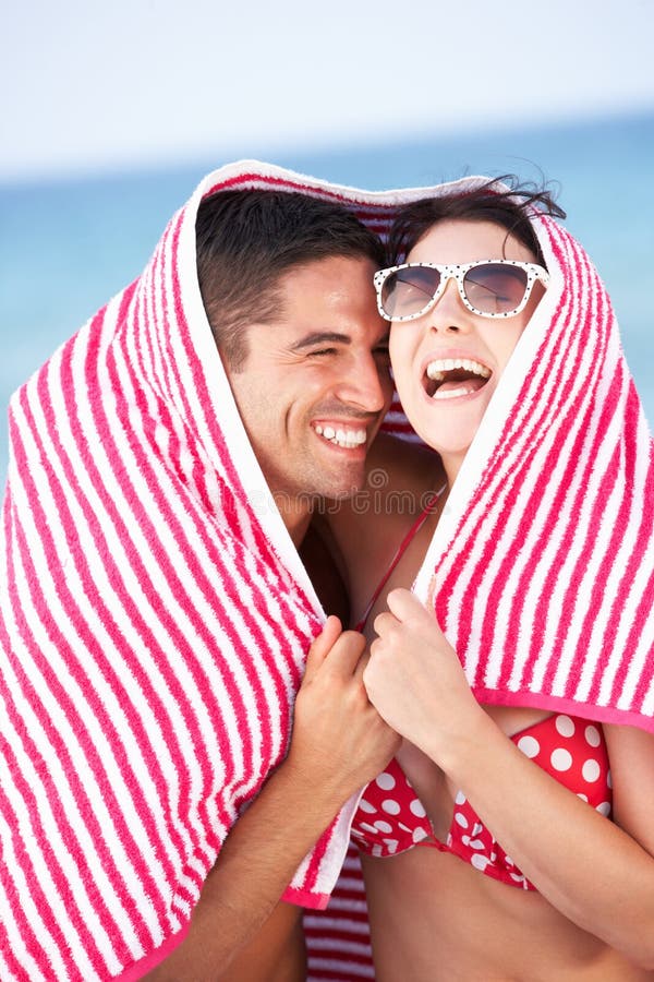 Couple Sheltering from Sun on Beach Holiday Stock Photo - Image of ...