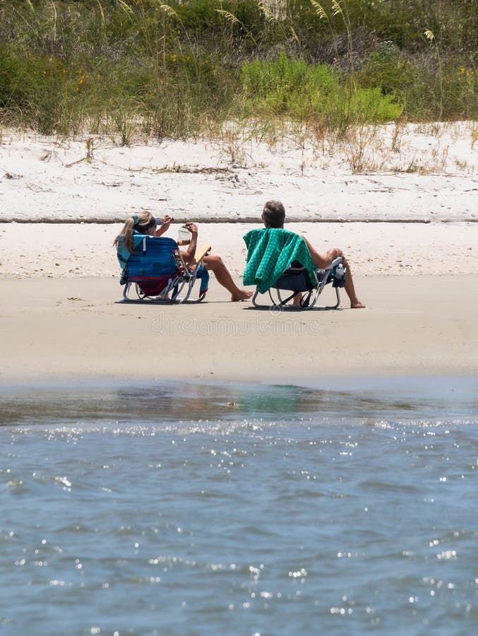 Couple Sitting in a Beach Chair on Grassy Shore Stock Photo - Image of ...
