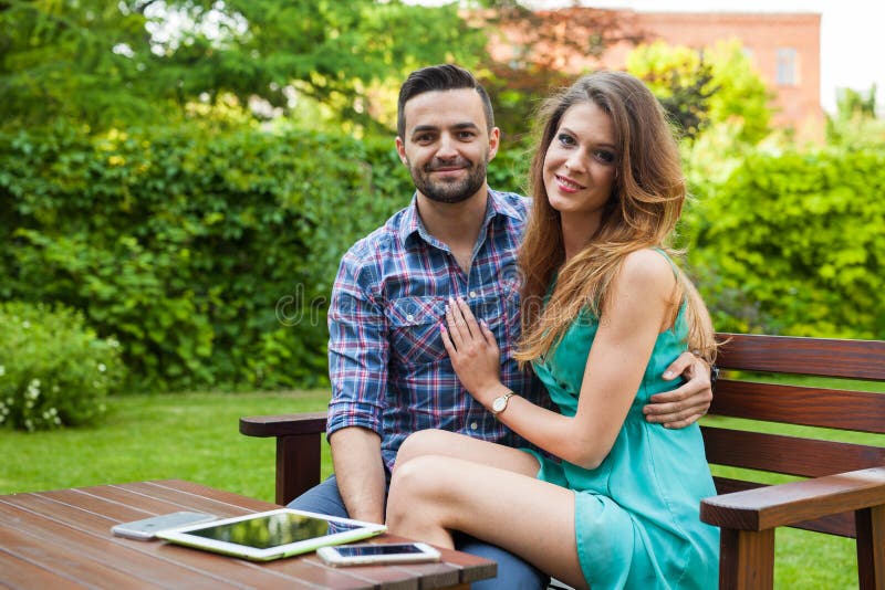 Couple Sitting on the Bench with Drinks and Spending Great Time. Stock ...