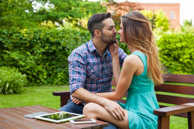 Couple Sitting on the Bench with Drinks and Spending Great Time. Stock ...