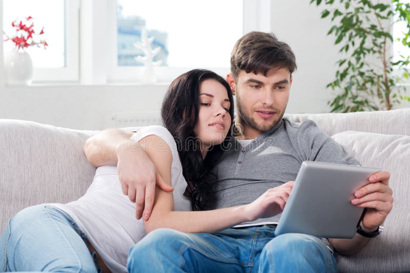 Couple Sitting on a Couch with Tablet Computers Stock Photo - Image of ...