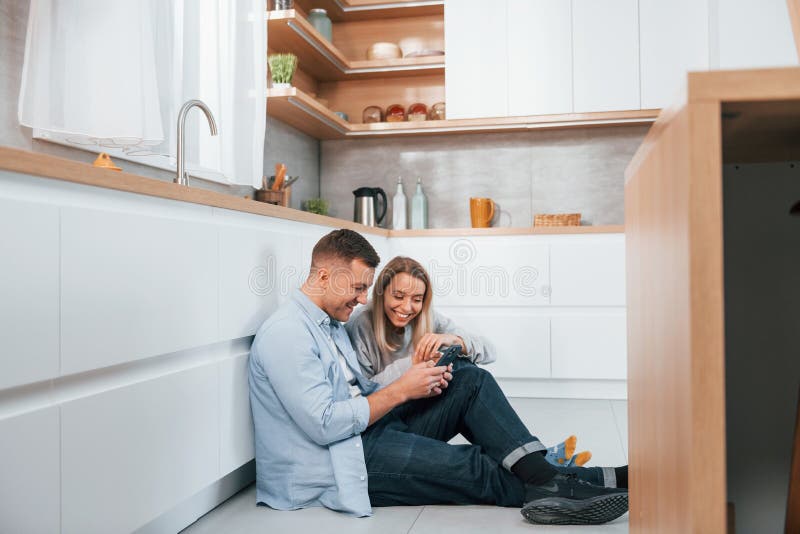 Couple Sitting on the Floor of Modern Kitchen Stock Image - Image of ...