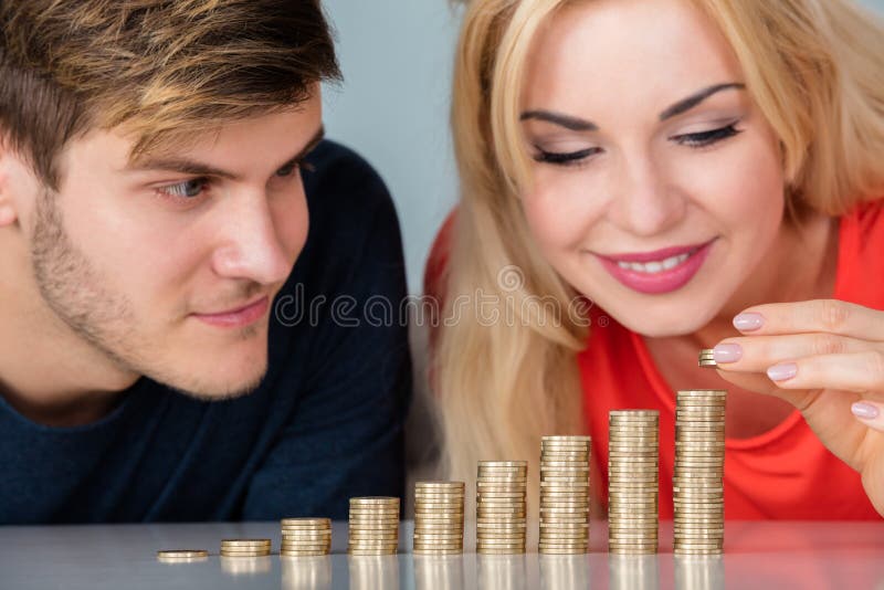 Couple Sitting with Stacks of Coins Over Table Stock Photo - Image of ...