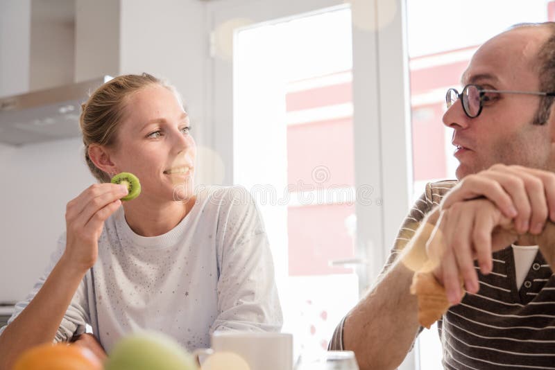 Couple Sitting and Talking at a Kitchen Table Stock Photo - Image of ...