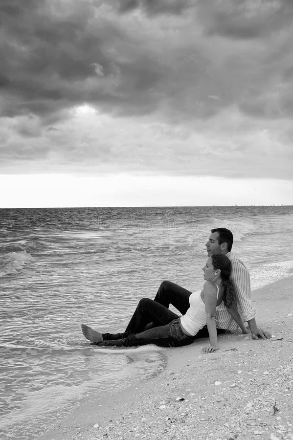 Couple Sitting in Water at the Beachin Black and W Stock Image - Image ...