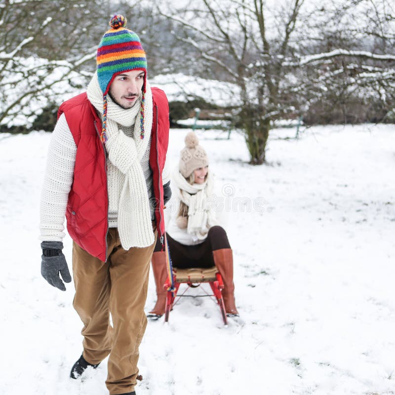 Couple Sledding in Winter through Snow Stock Image - Image of outdoors ...