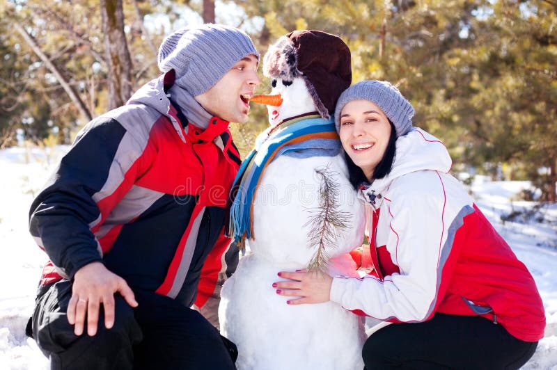 Couple with a snowman stock photo. Image of relations - 21993964