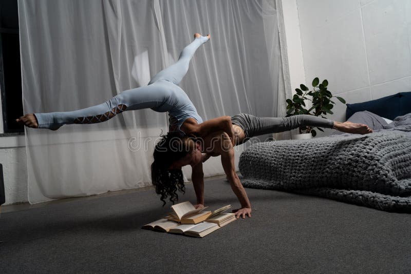 Couple Spending Time Together Reading Book and Making Acrobatic Balance ...