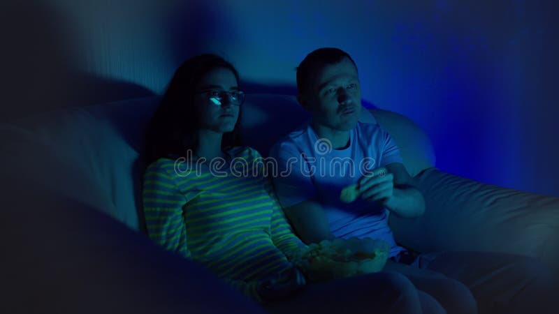 Couple Spending Time Watching Tv Late At Night Sitting On The Couch