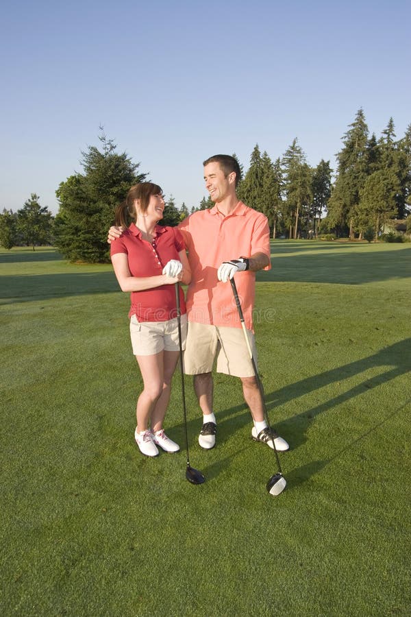 Couple Standing on Golf Course - Vertical Stock Image - Image of clubs ...