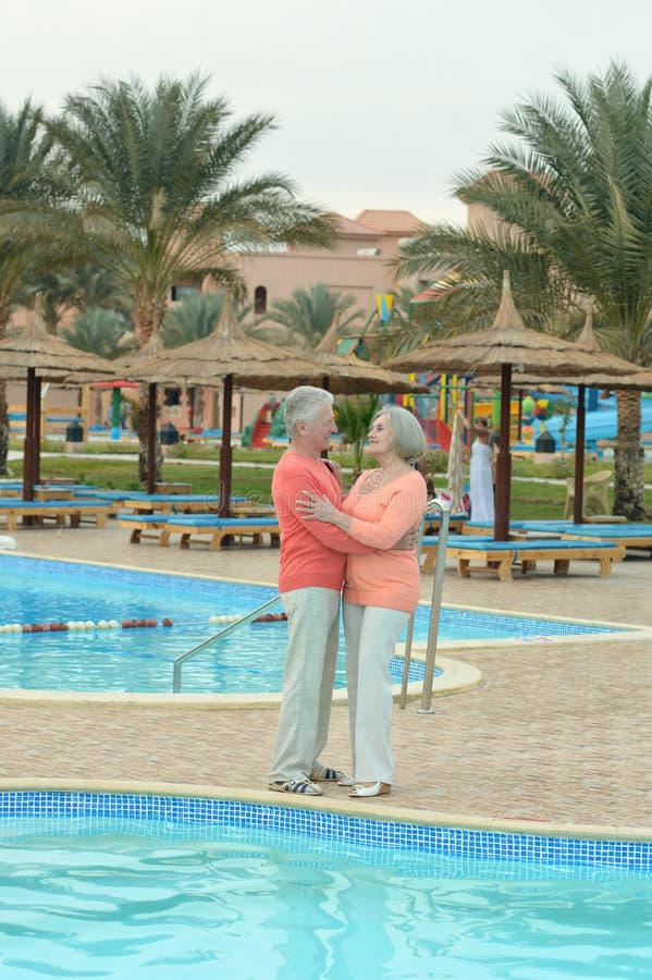 Couple standing by pool stock photo. Image of mature - 53378802
