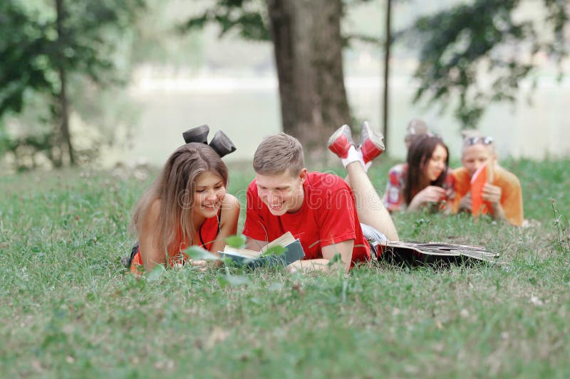 Couple of Students Lying on the Grass in the Park and Reading a Book ...