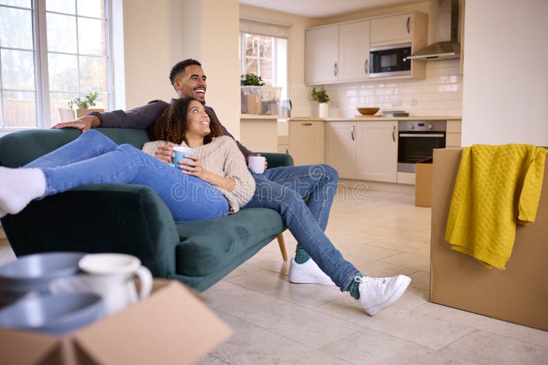 Couple Taking a Break from Unpacking Boxes Sitting on Sofa Looking ...