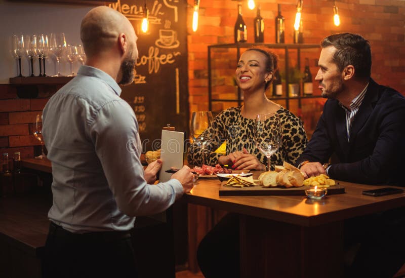 Couple Talking To Bartender Behind Bar Counter in a Cafe Stock Image ...