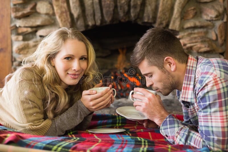 Couple with Tea Cups in Front of Lit Fireplace Stock Image - Image of ...