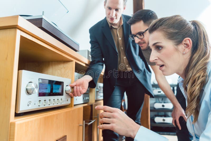 Couple Testing a Hi-Fi System in the Store with the Salesman Stock ...