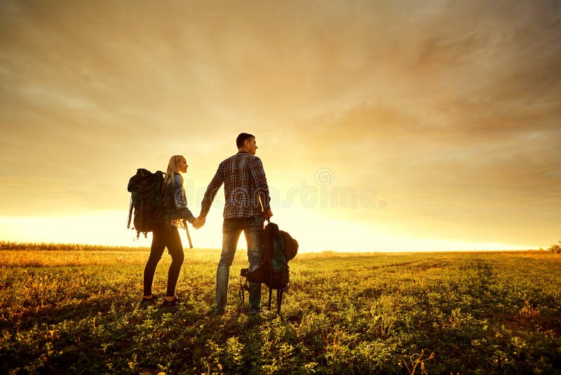 A Couple of Tourists with Backpacks on the Nature at Sunset. Stock ...