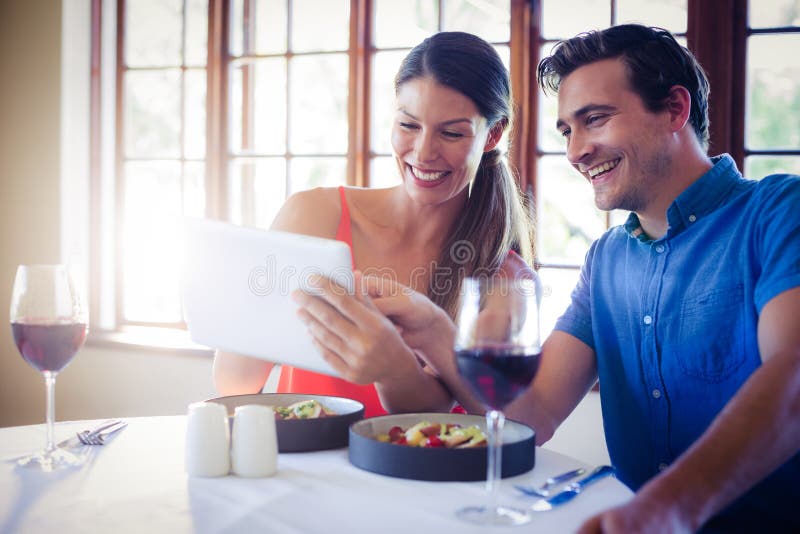 Couple Using a Digital Tablet during Lunch Stock Photo - Image of ...