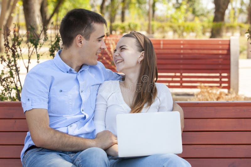 Couple Using a Laptop Outdoors and Looking Happy Stock Photo - Image of ...