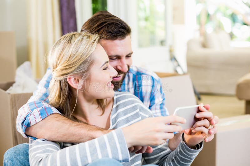 Couple Using Mobile Phone in Living Room Stock Image - Image of homey ...