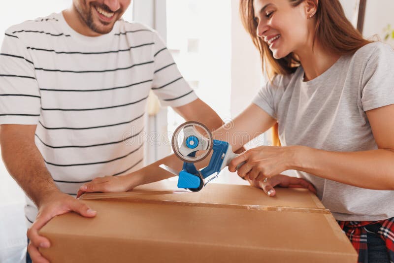 Couple Using Packing Machine Taping Boxes while Moving Stock Photo ...