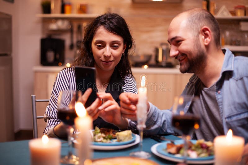 Couple Using Phone during Dinner Stock Photo - Image of delighted ...