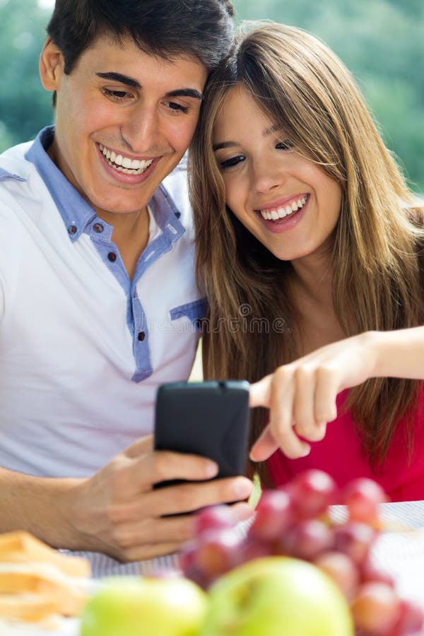 Couple Using Smart Phone on Romantic Picinic. Stock Photo - Image of ...