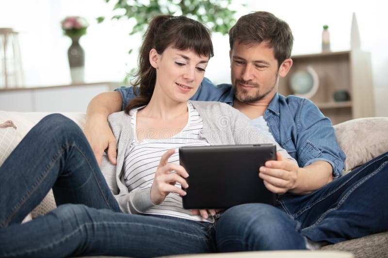 Couple Using Tablet Computer in Their Living Room Stock Image - Image ...