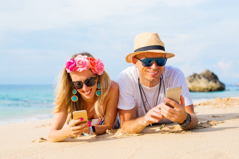 Couple Using Their Phones on the Beach Stock Photo - Image of holiday ...