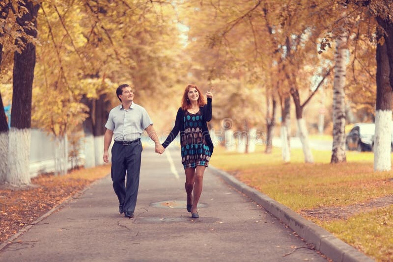 Couple walk in autumn park stock photo. Image of girl - 63266616