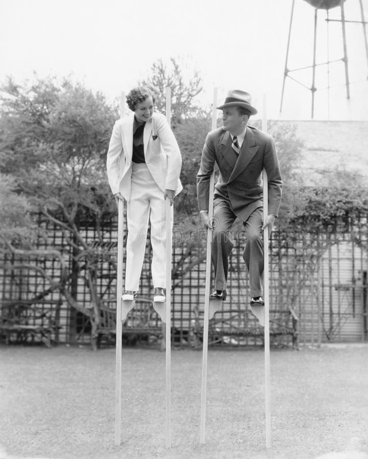 Couple walking on stilts stock photo. Image of 19101940 - 52021598