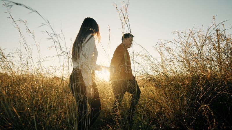 Couple Walks Outdoor in a Field at Sunset Stock Photo - Image of ...