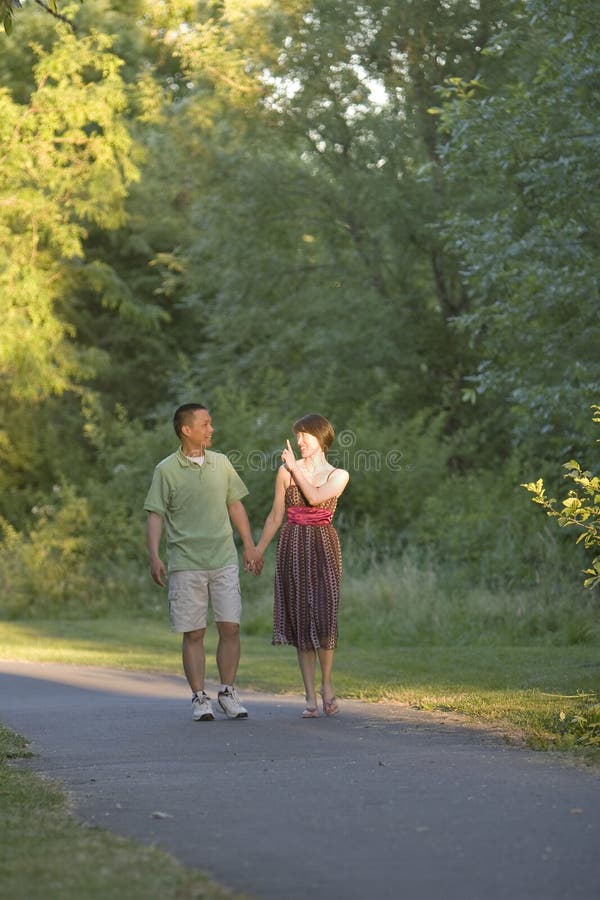 Couple Walks on Path Talking - Vertical Stock Photo - Image of partners ...