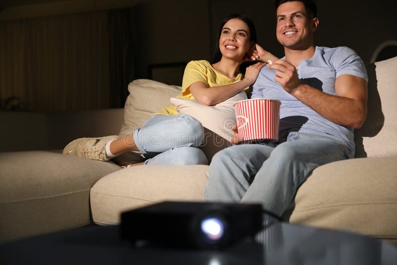 Couple Watching Movie with Popcorn on Sofa at Night Stock Photo - Image ...