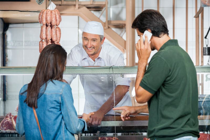 Couples De Selling Meat To De Boucher Dans La Boucherie Photo stock ...